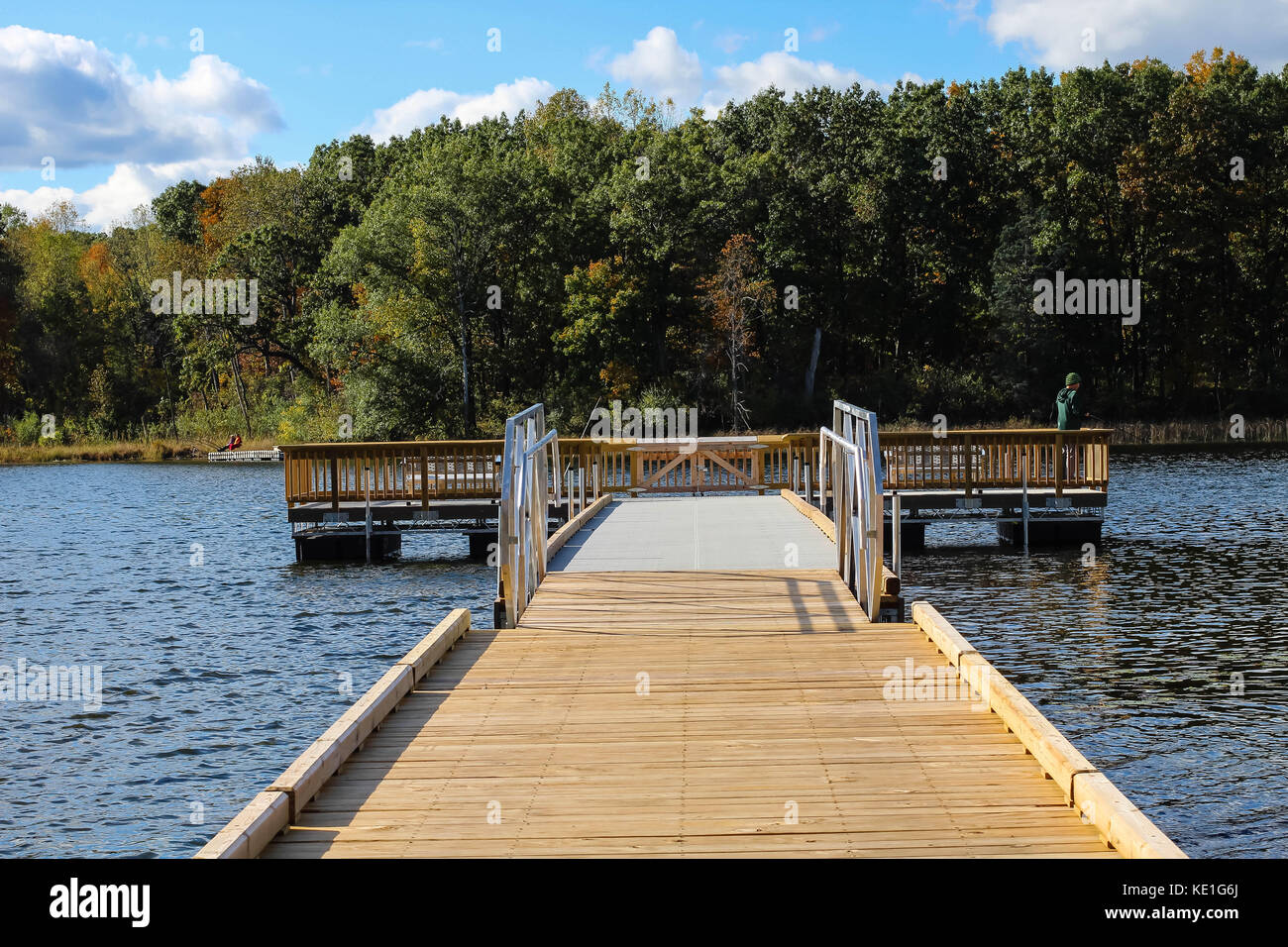A dock on the water with pretty trees in the background at a park in ...
