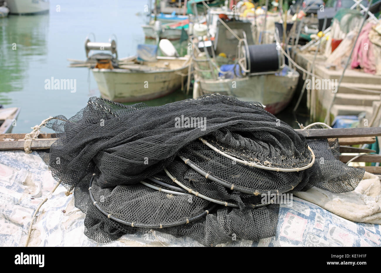 fishing nets and fishing boats in a small harbor Stock Photo - Alamy