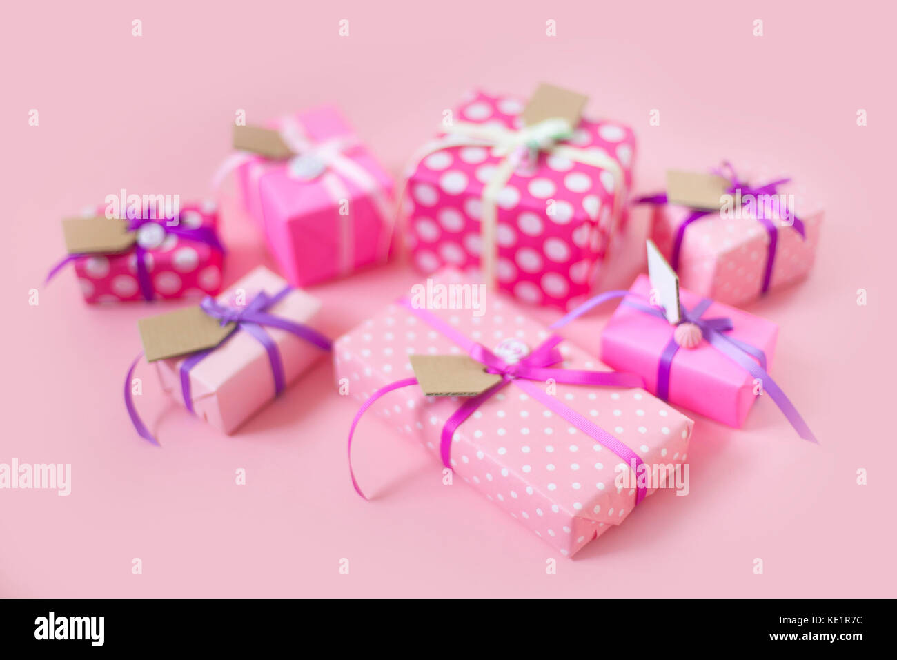 Colored gift boxes with colorful ribbons. Pink background. Gifts for St ...