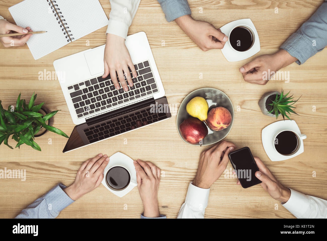 top view of businesspeople on meeting with laptop and coffee at ...