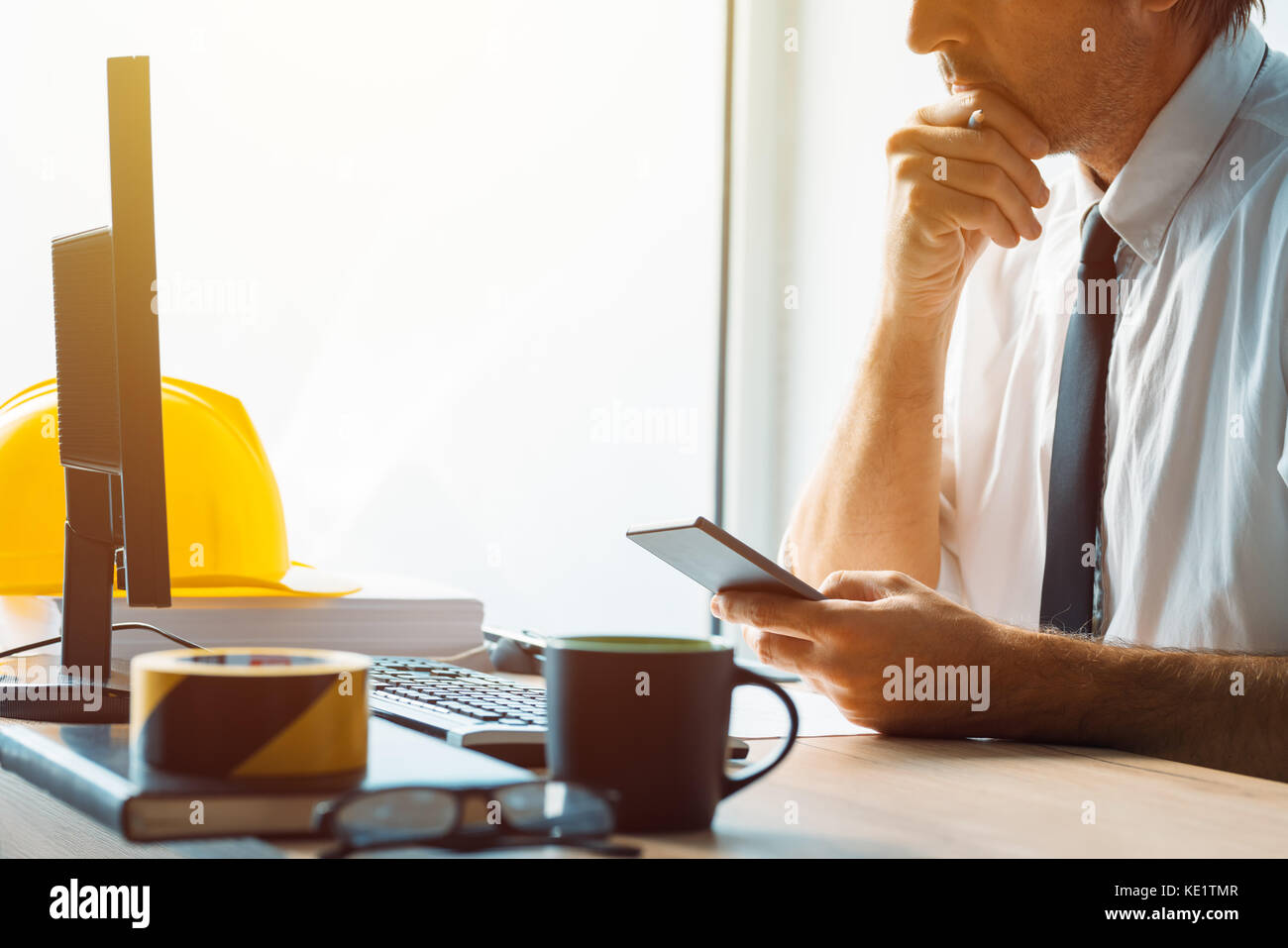 Civil engineer using smartphone in architecture office. Adult caucasian ...