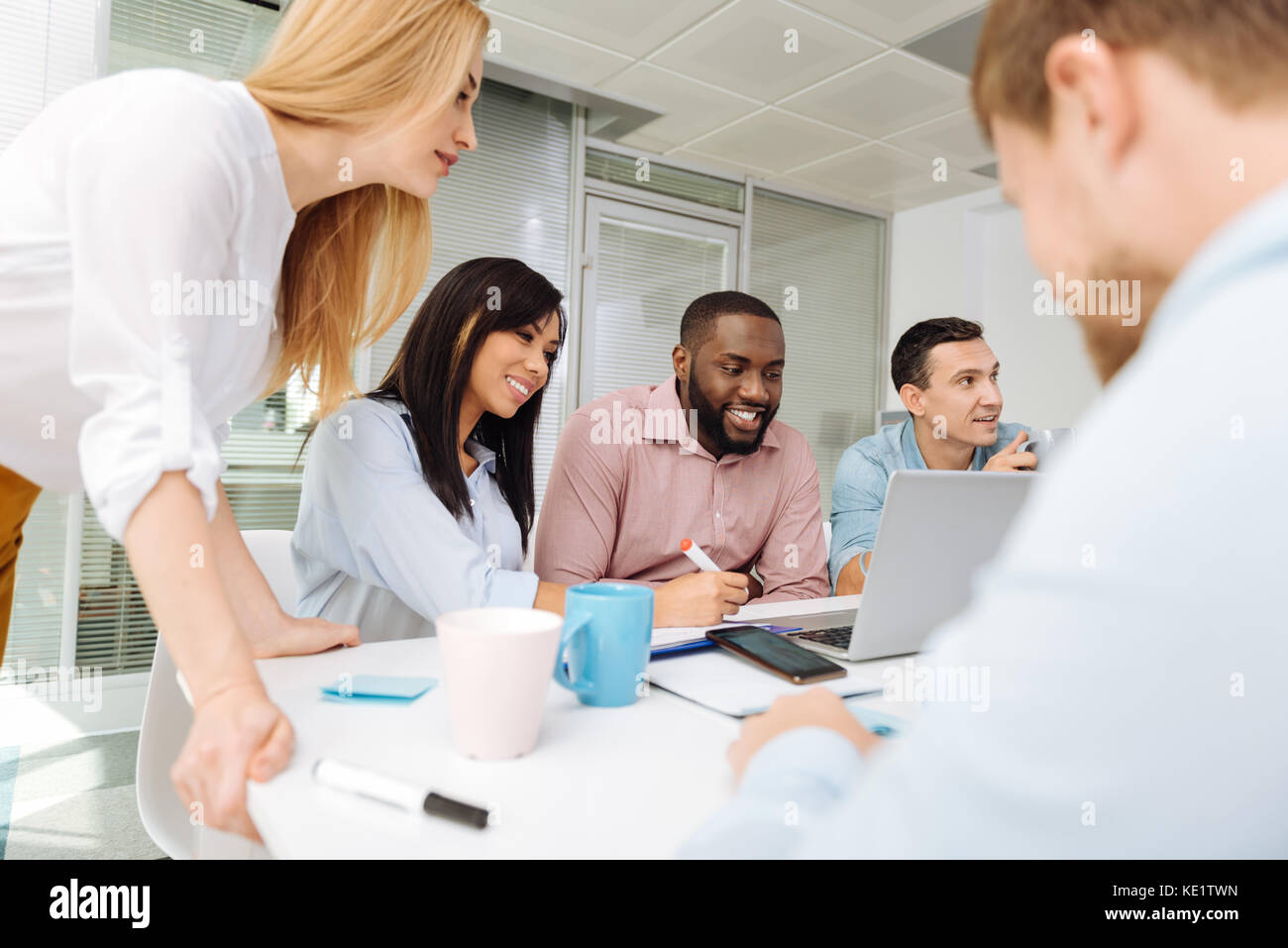 Attentive woman checking her colleagues Stock Photo - Alamy