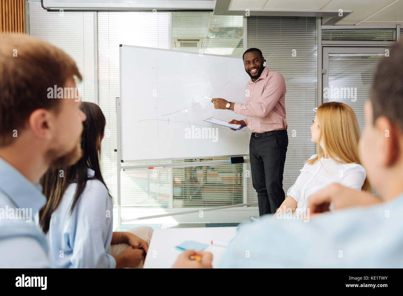 Joyful international man presenting his project Stock Photo - Alamy