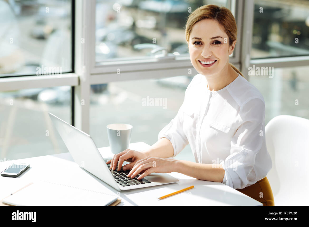 Positive delighted female typing new document Stock Photo - Alamy