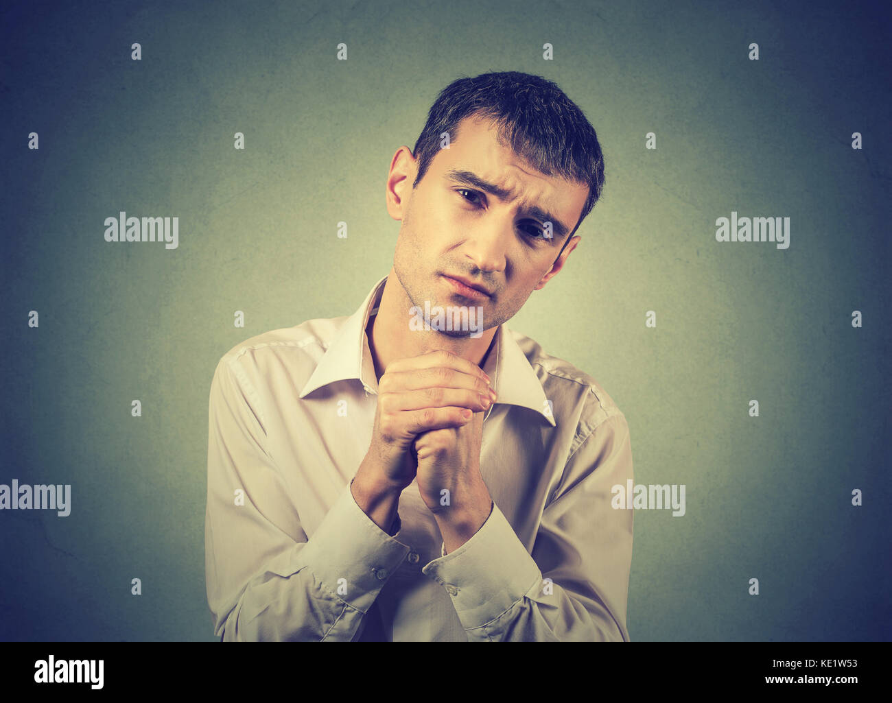 Closeup portrait of desperate young man showing clasped hands, please ...