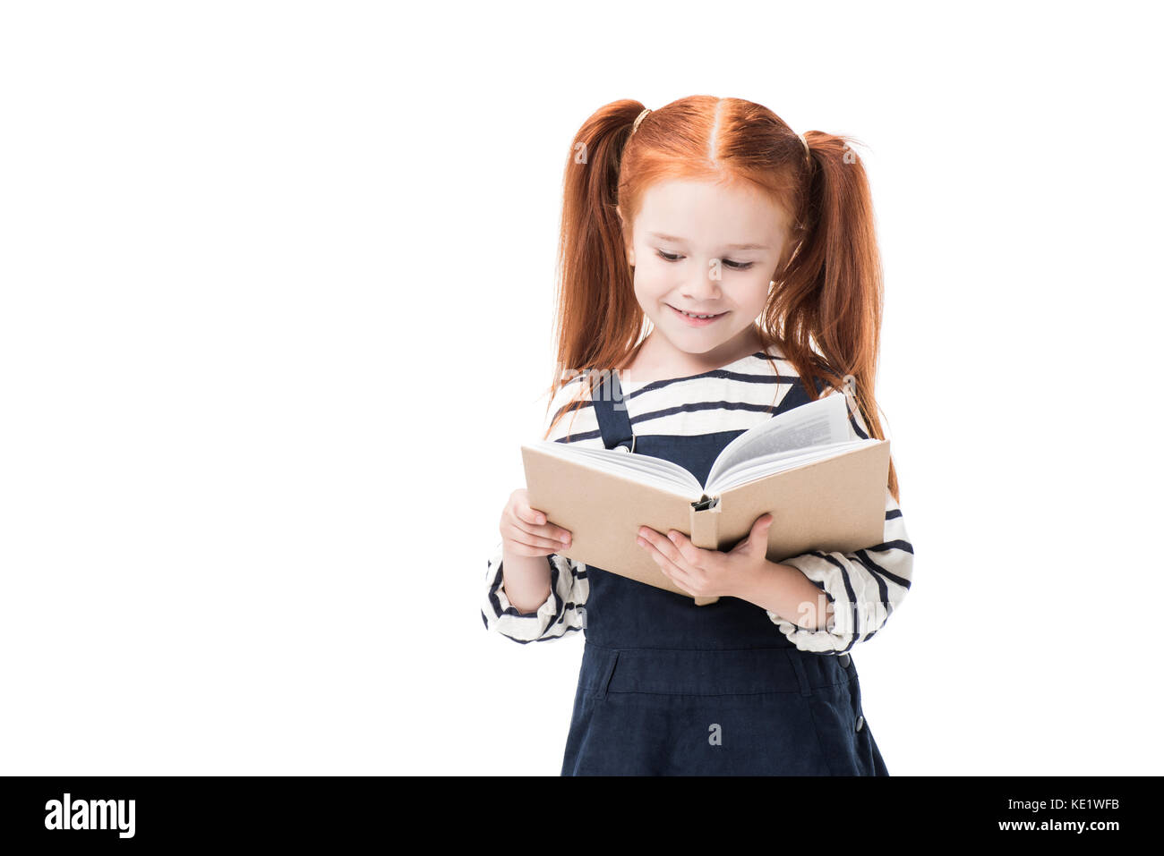 Cute smiling elementary school student reading book isolated on white ...