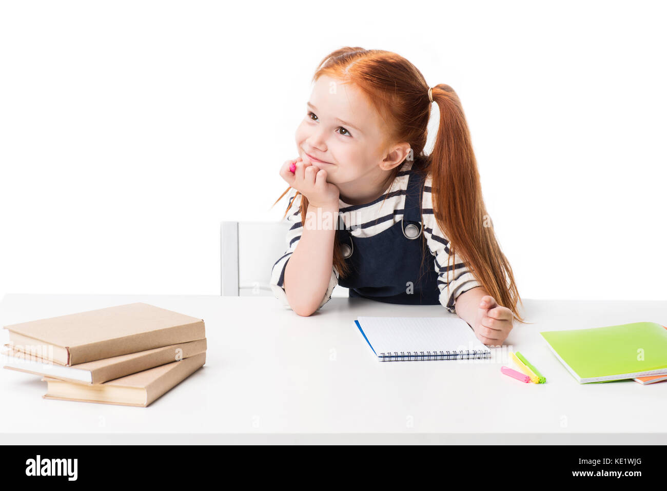 pensive smiling schoolgirl drawing with felt tip pens and looking away ...