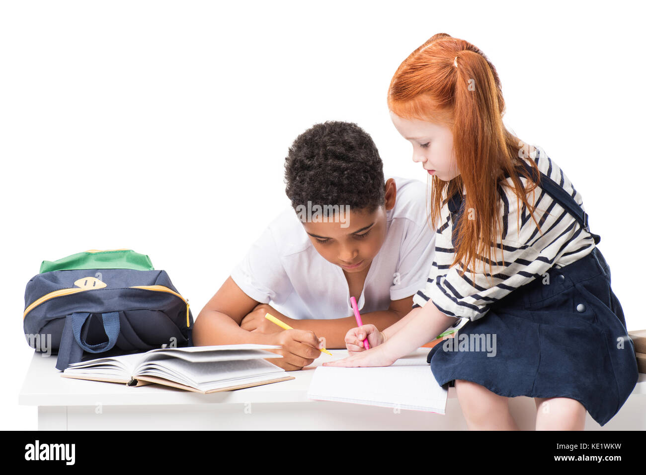 cute focused multiethnic schoolkids studying together isolated on white ...