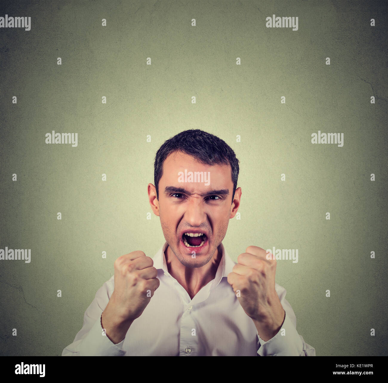 Portrait angry displeased young man screaming isolated on gray wall ...