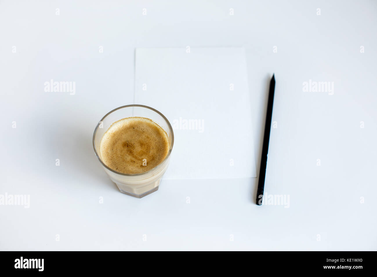 top view of cup of coffee on white paper with pencil, isolated on white ...