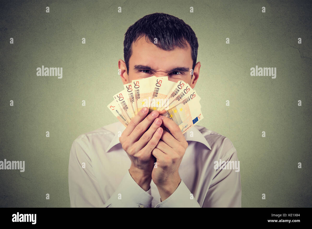 Greedy man with euro banknotes bills isolated on gray wall background ...