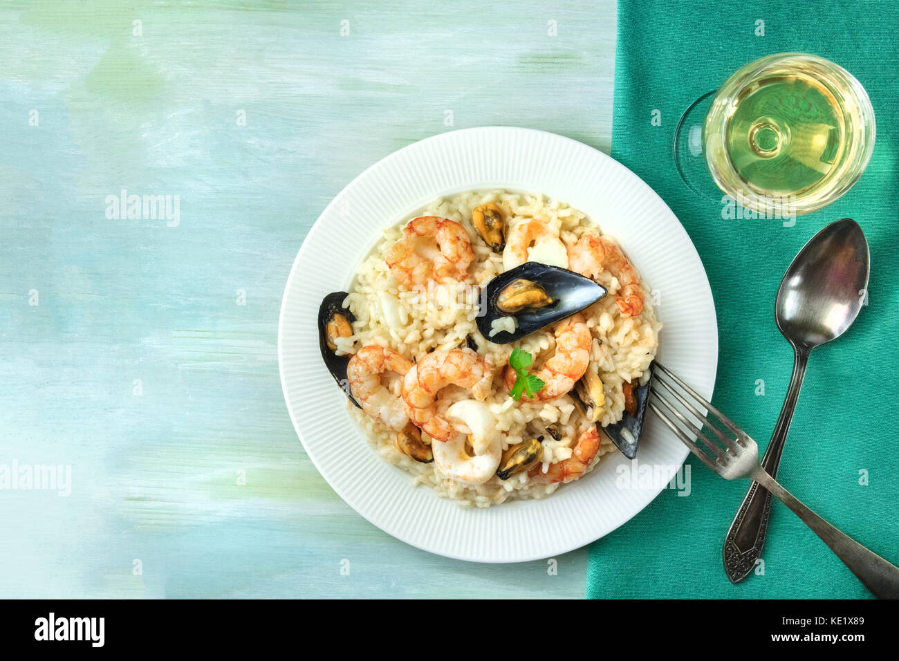 Seafood risotto plate on teal textures with copyspace Stock Photo - Alamy