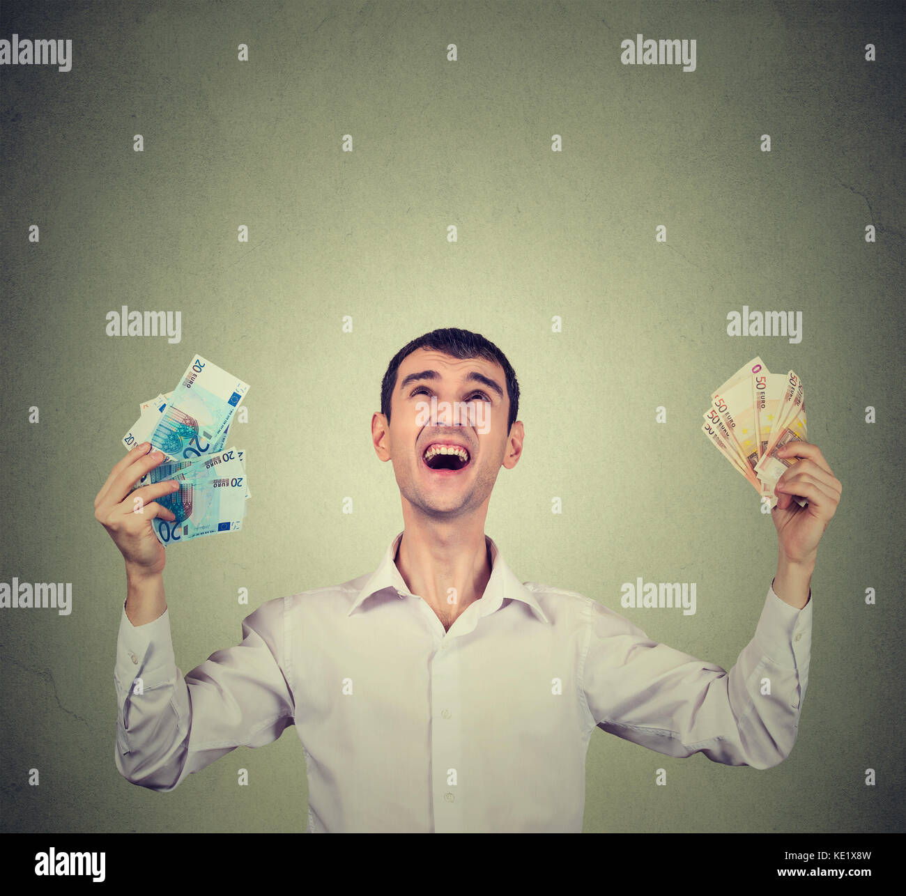 Portrait happy man ecstatic celebrates success holding money euro bills ...