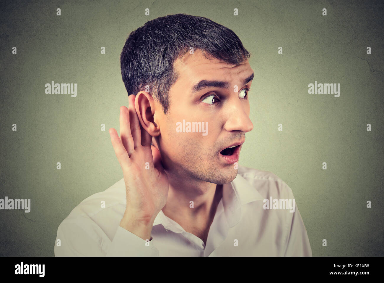 Closeup portrait hard of hearing man placing hand on ear asking someone ...