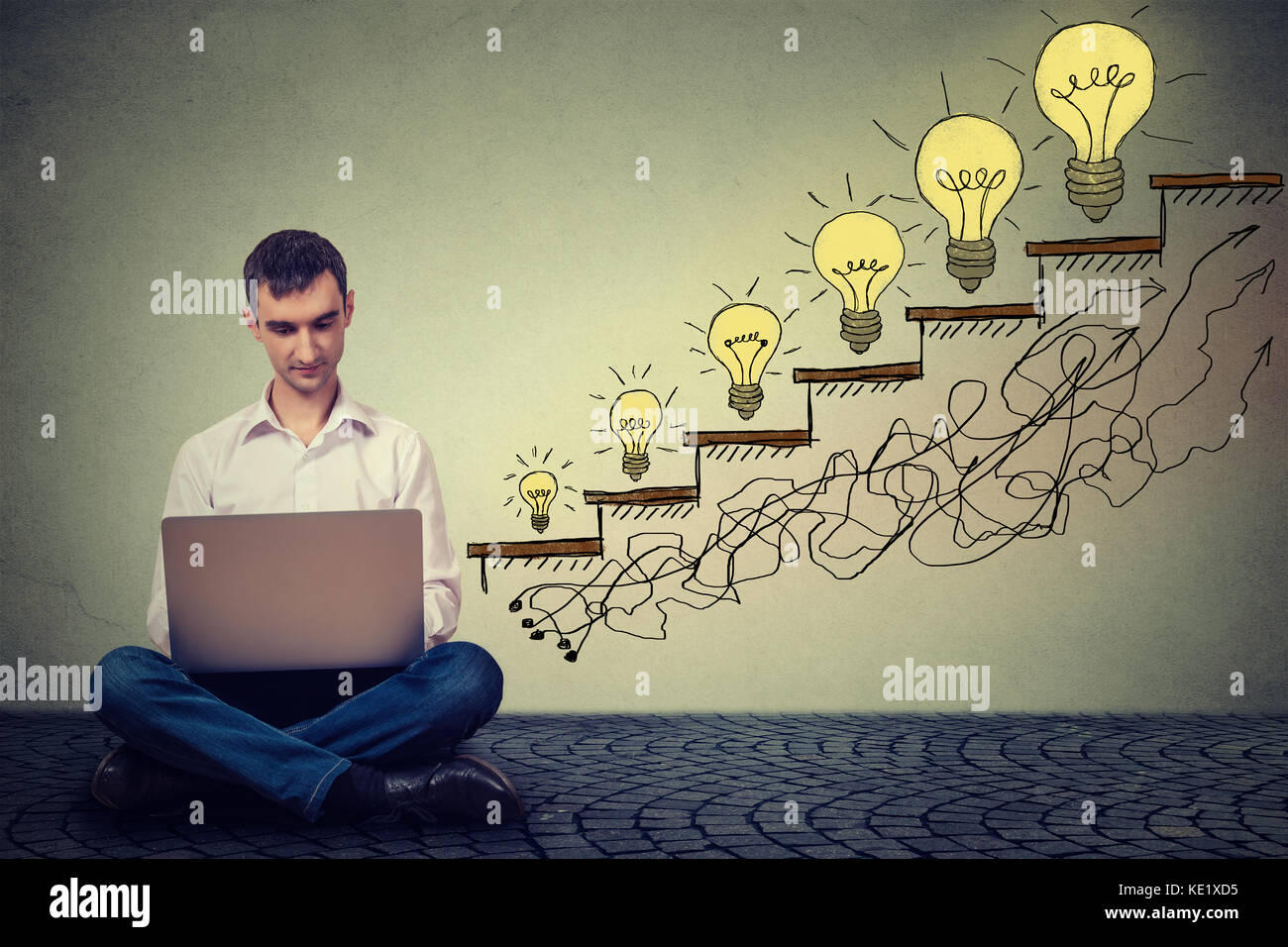 Happy young man entrepreneur working on computer sitting on a floor in ...