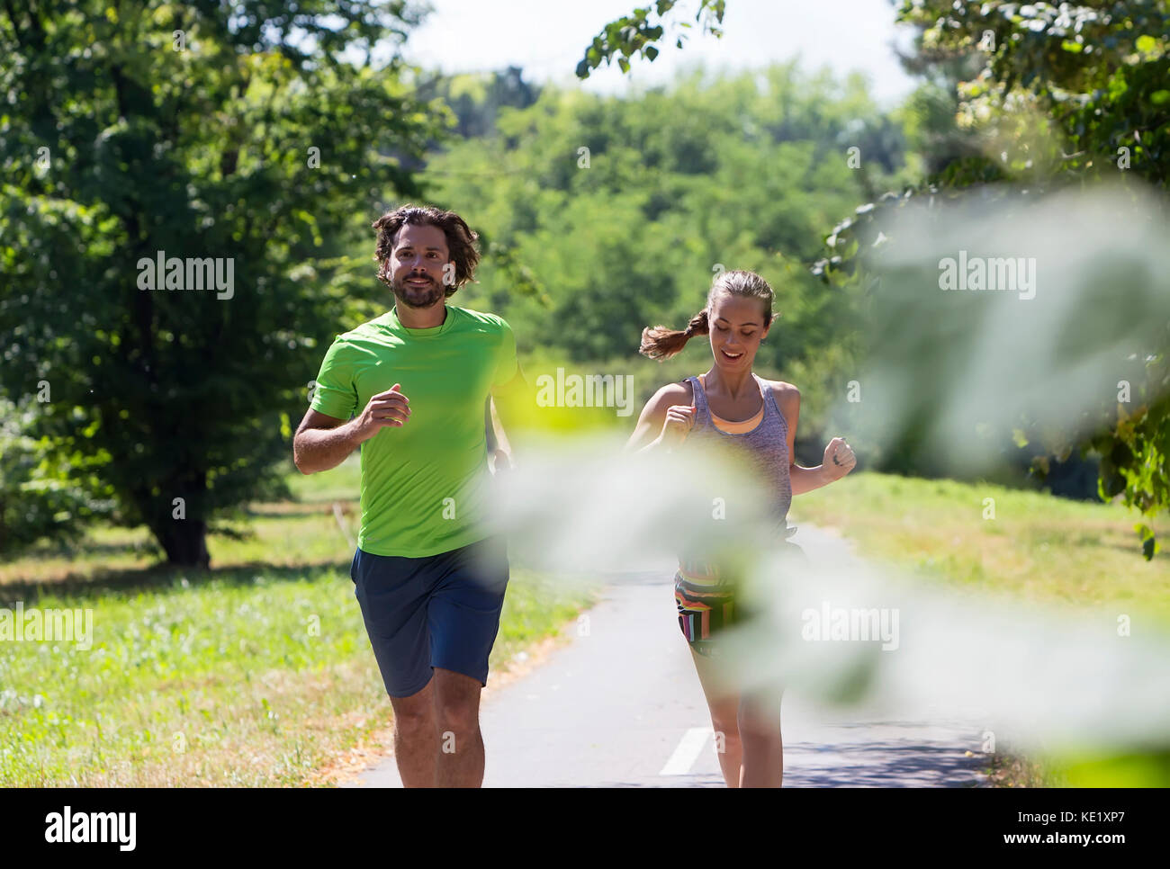 Healthy, fit and sportive couple running in park at summer morning ...