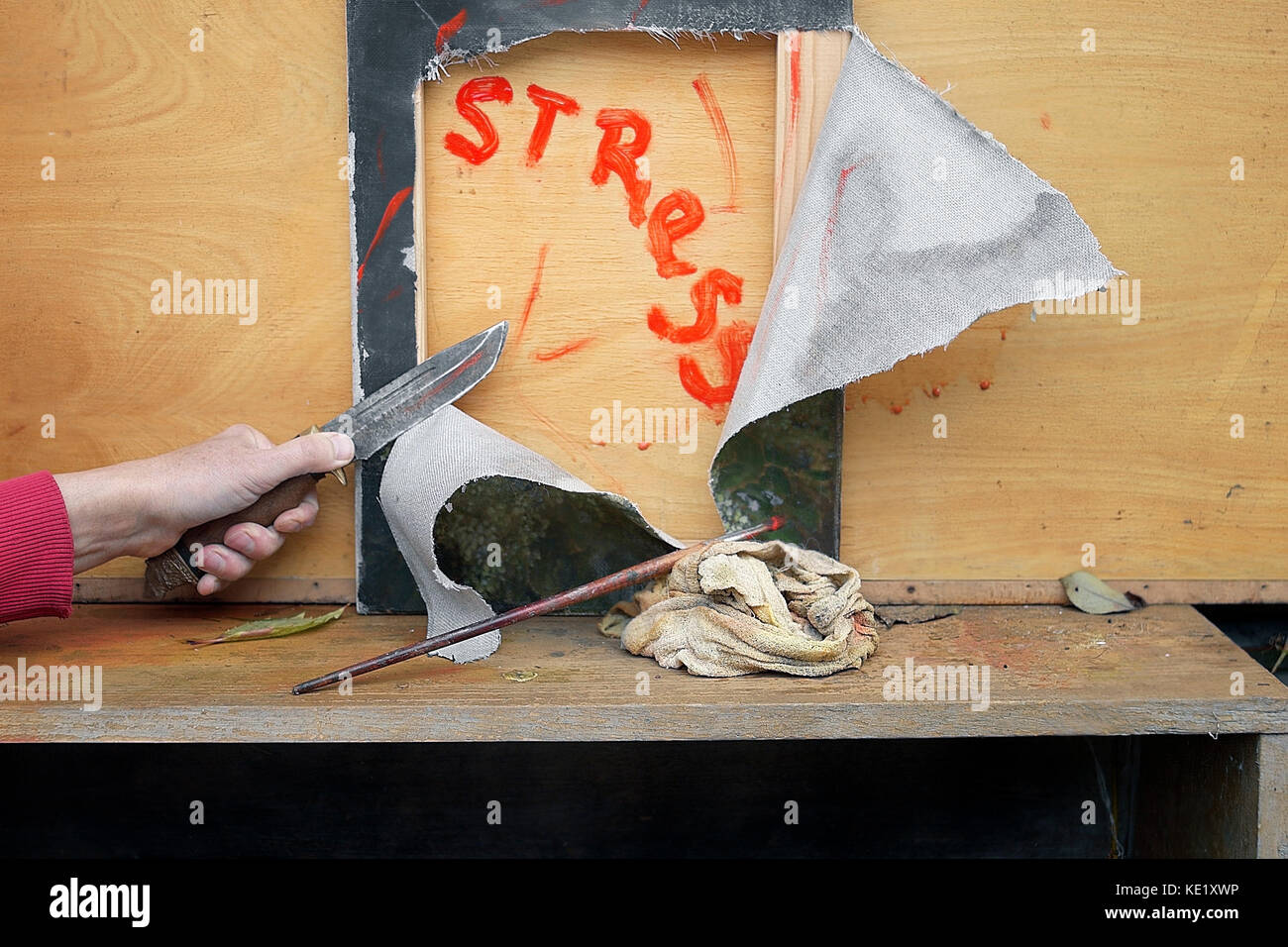 Artist in stress cutting his artwork with knife, outdoor cropped photo ...