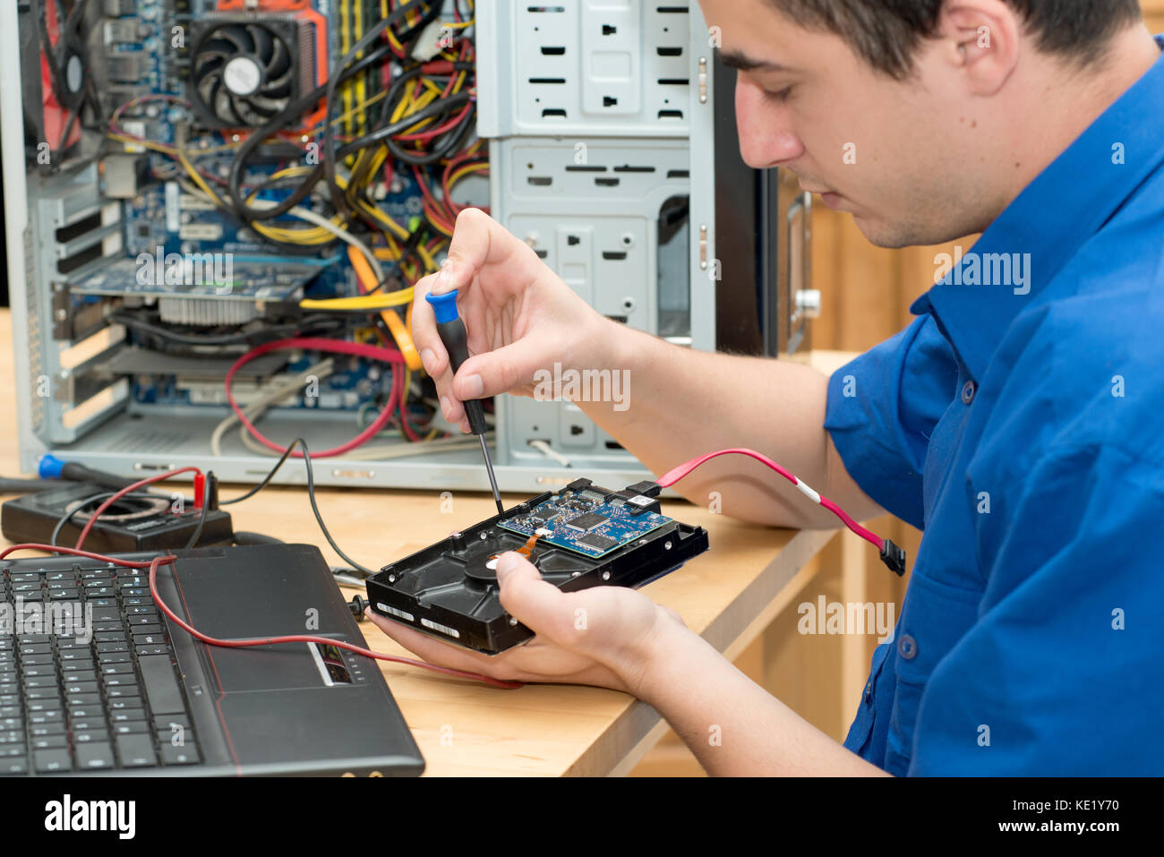 a young technician working on broken computer in his office Stock Photo ...