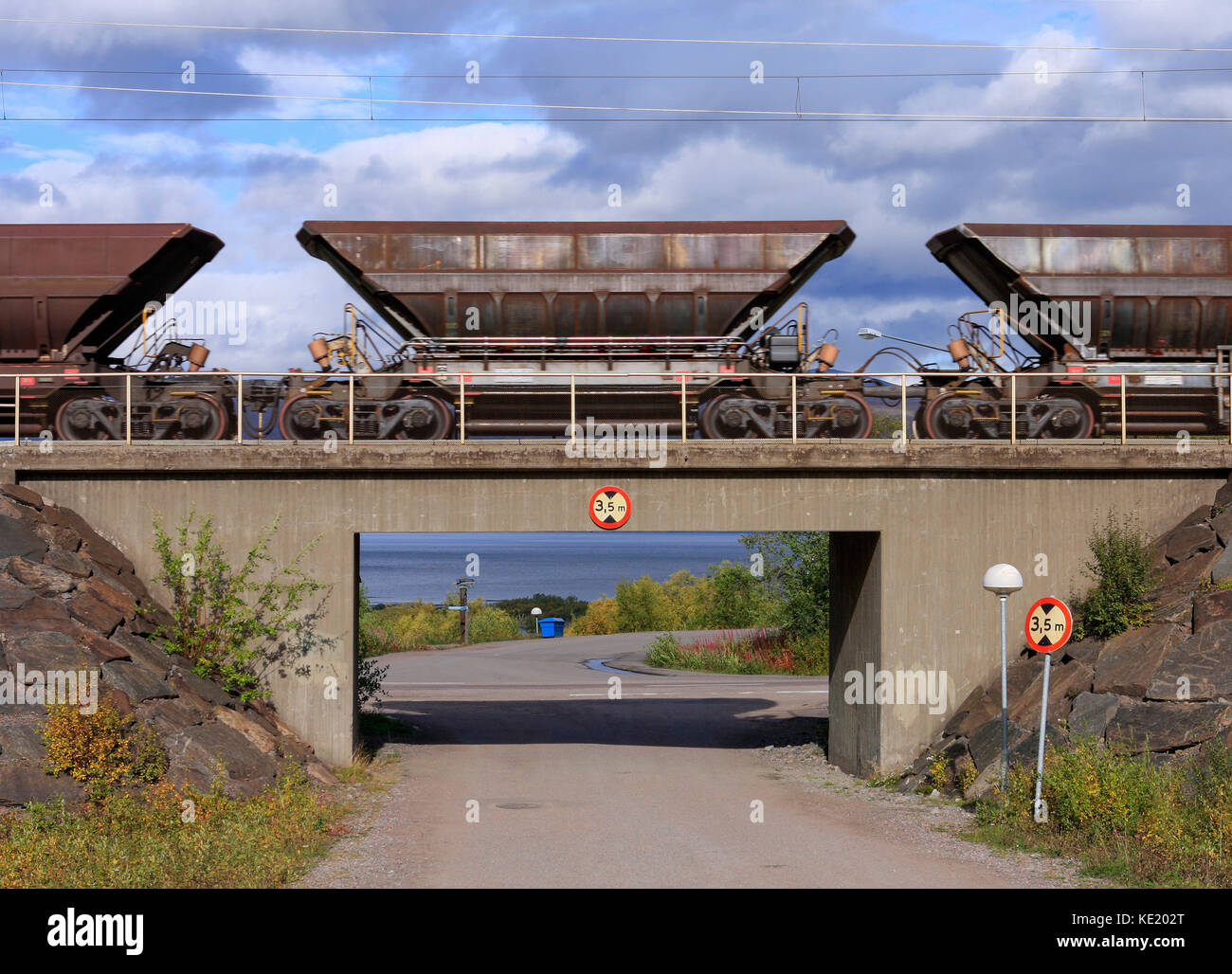 Bridge and a road passes under the Ore Line. Power lines above. Sign ...