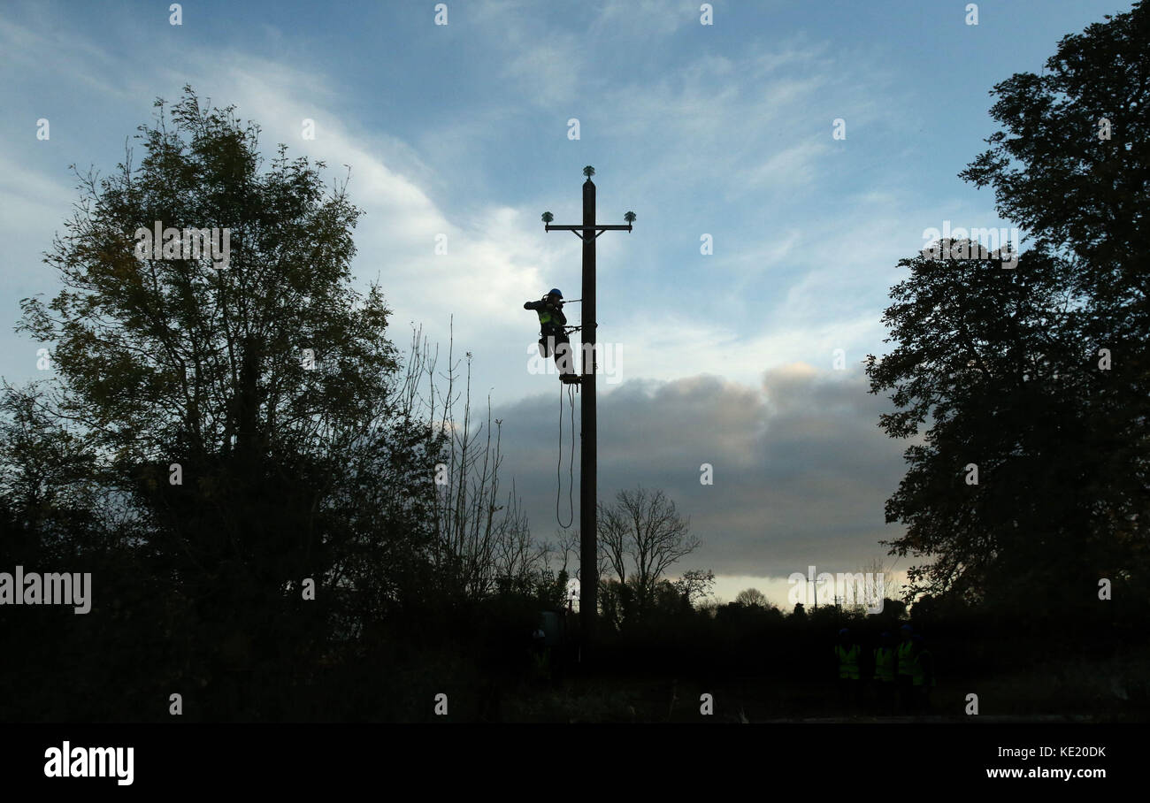 Workers in Kilcock, Ireland, clear fallen power lines after Hurricane ...