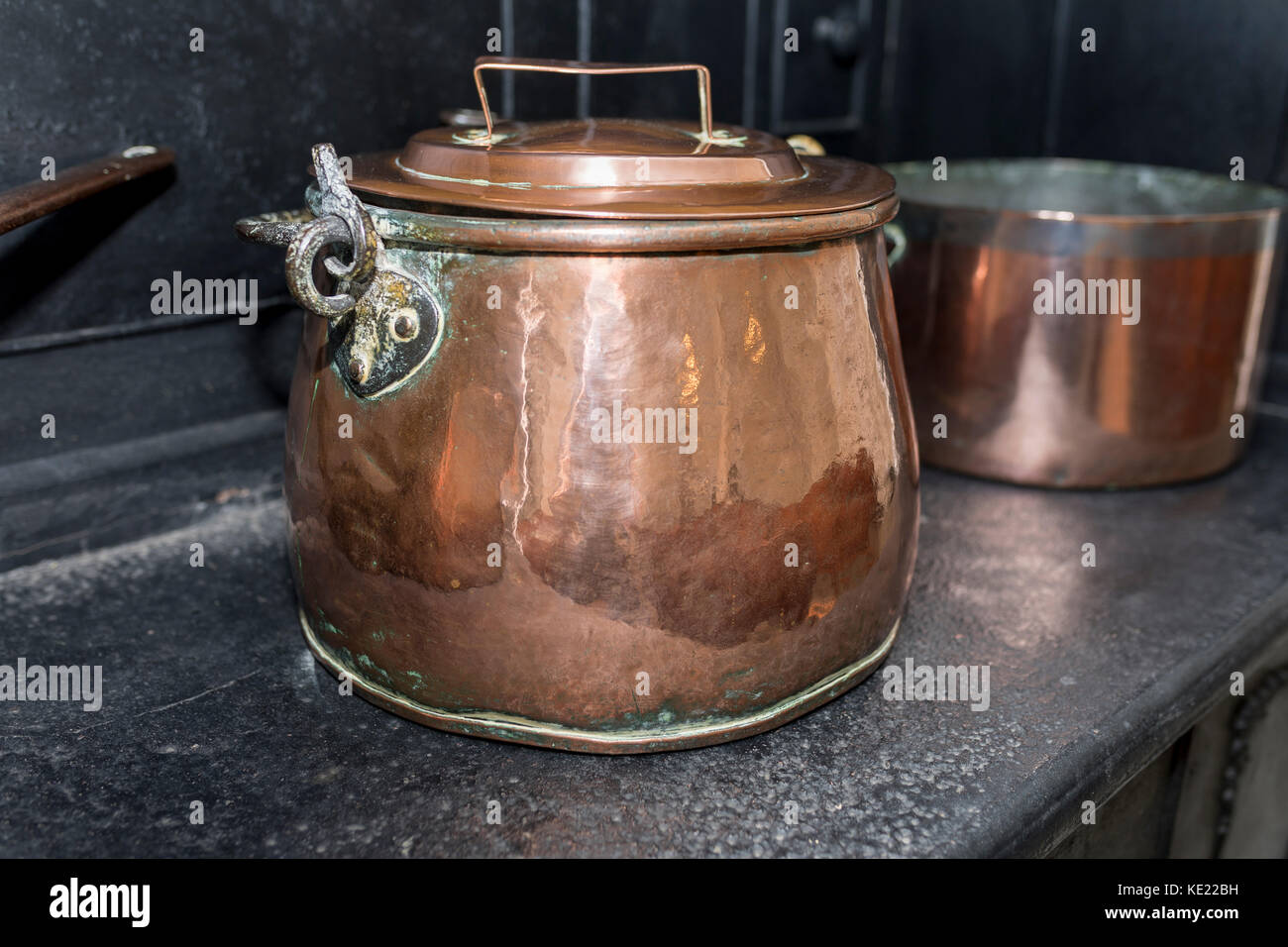 Victorian copper casserole pan on a black antique gas stove in a ...