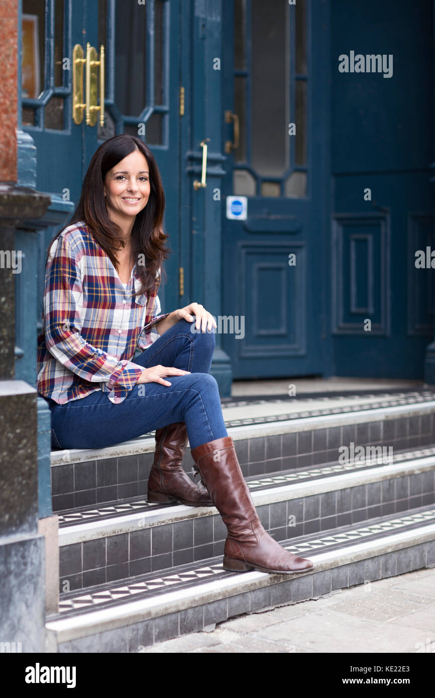 young woman sitting on her doorstep Stock Photo - Alamy