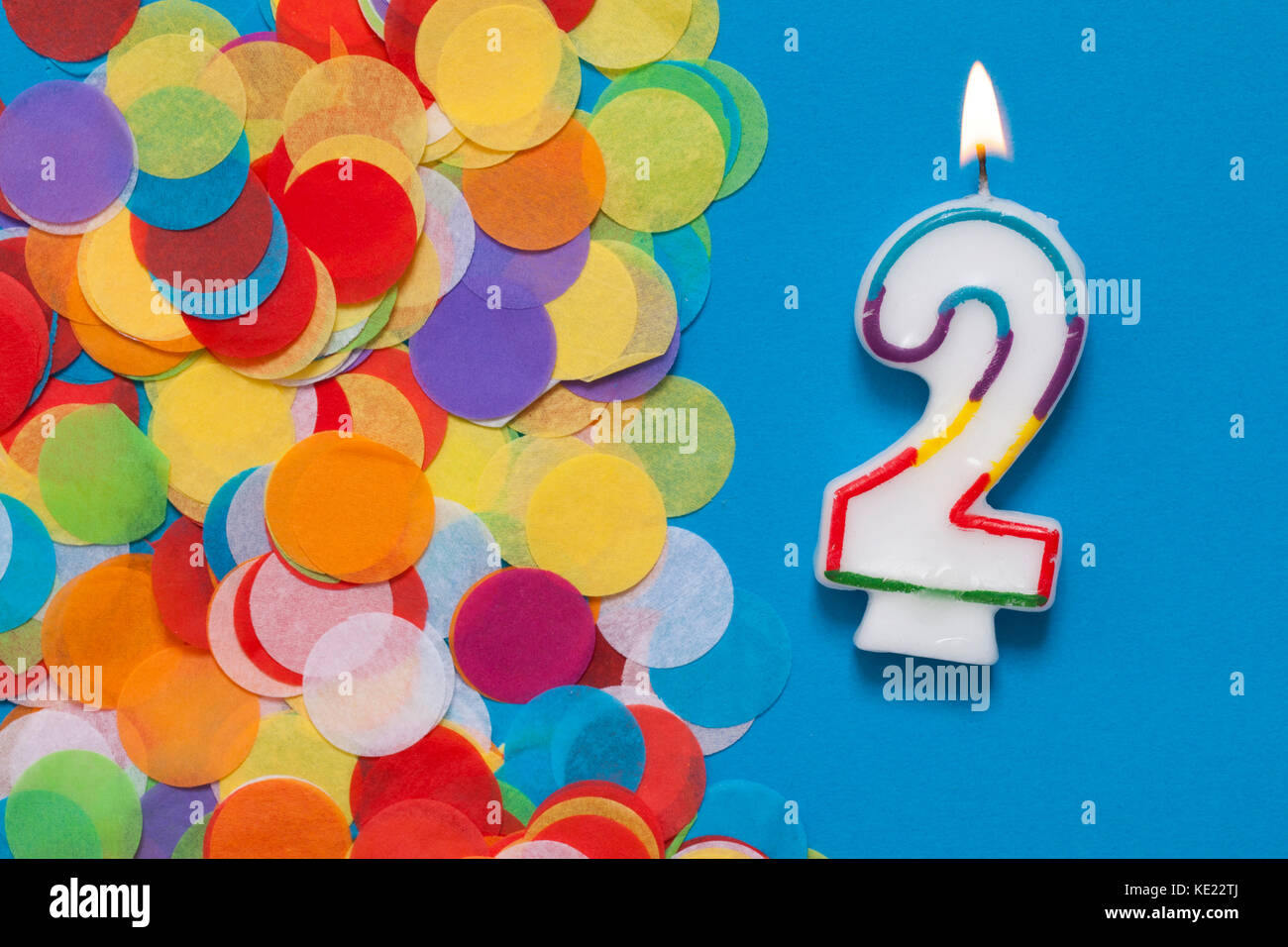Number 2 celebration candle with party confetti Stock Photo - Alamy