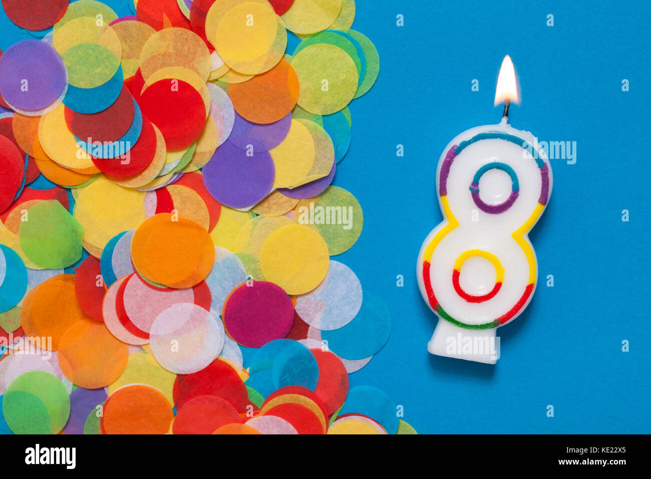 Number 8 celebration candle with party confetti Stock Photo - Alamy
