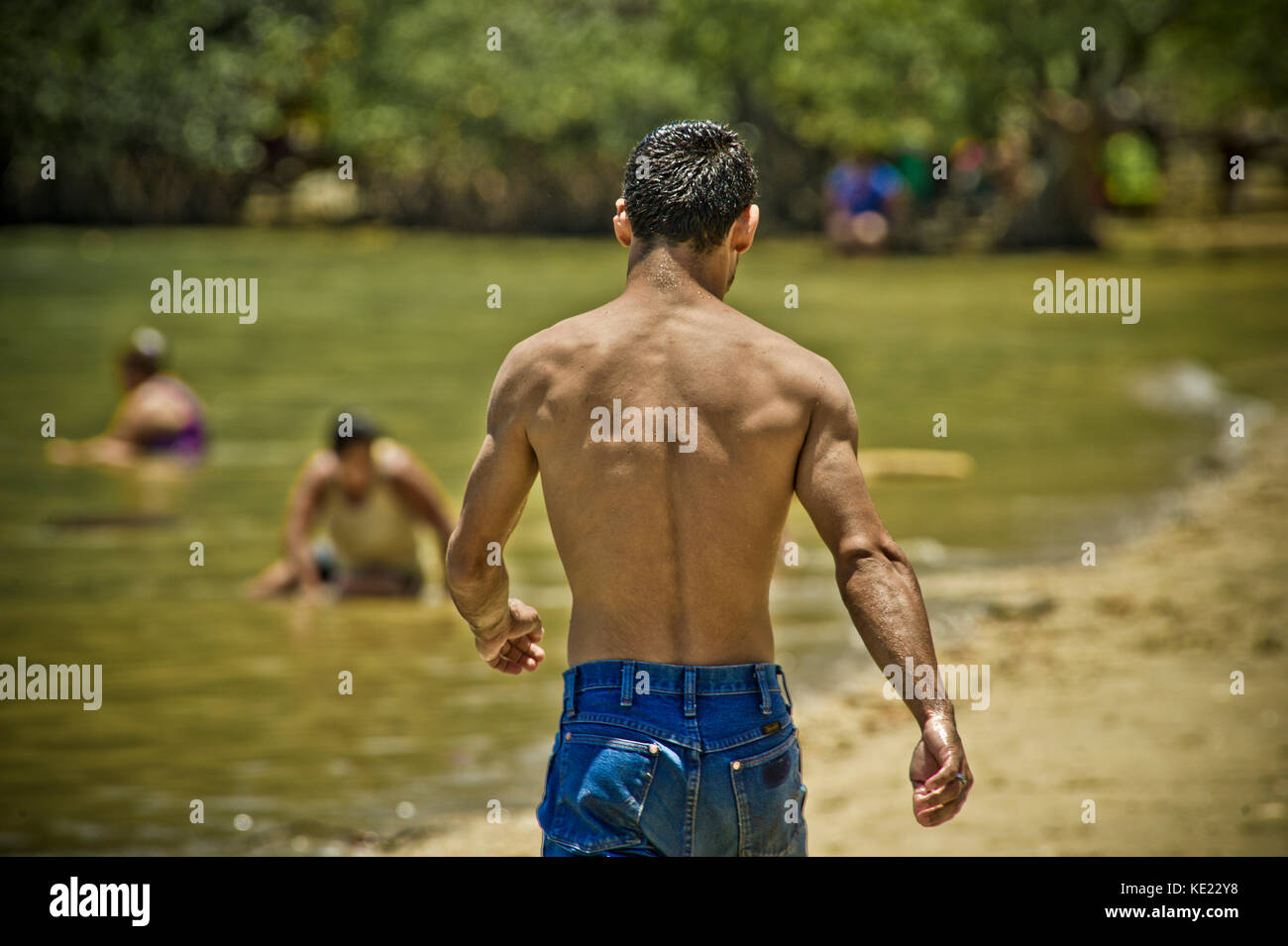 Young Costa Rican man walking on the beach at Papagayo Bay near Liberia ...