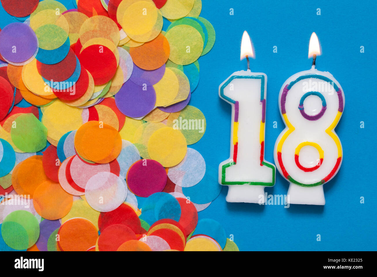 Number 18 celebration candle with party confetti Stock Photo - Alamy