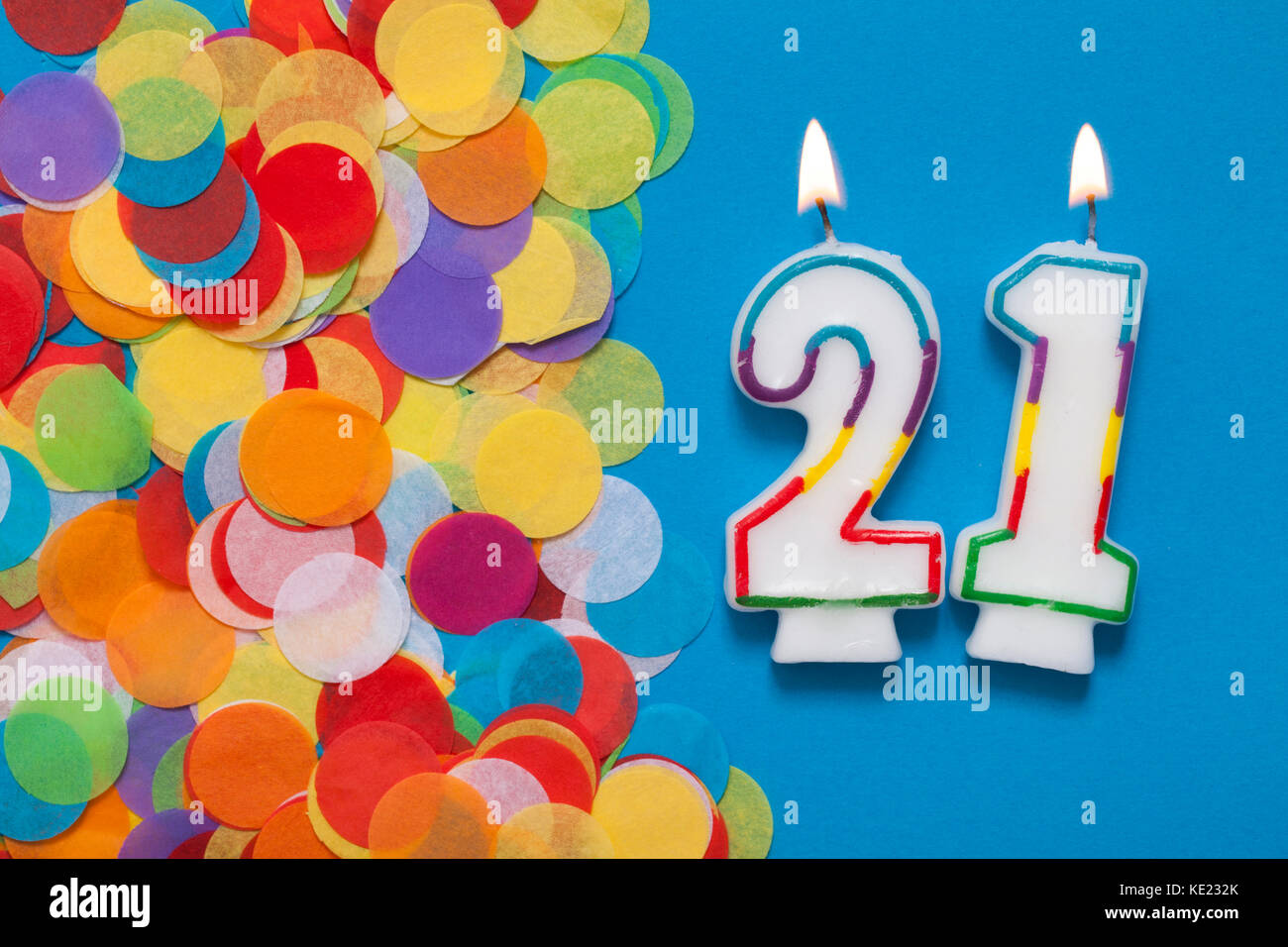 Number 21 celebration candle with party confetti Stock Photo - Alamy