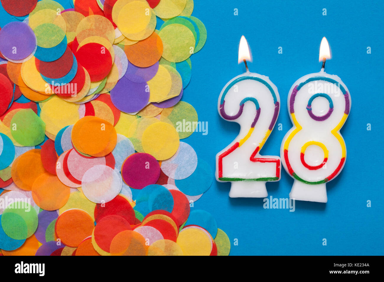 Number 28 celebration candle with party confetti Stock Photo - Alamy