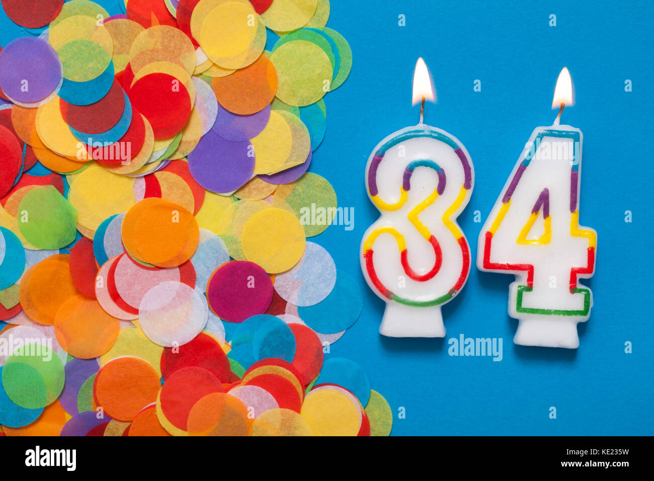 Number 34 celebration candle with party confetti Stock Photo - Alamy
