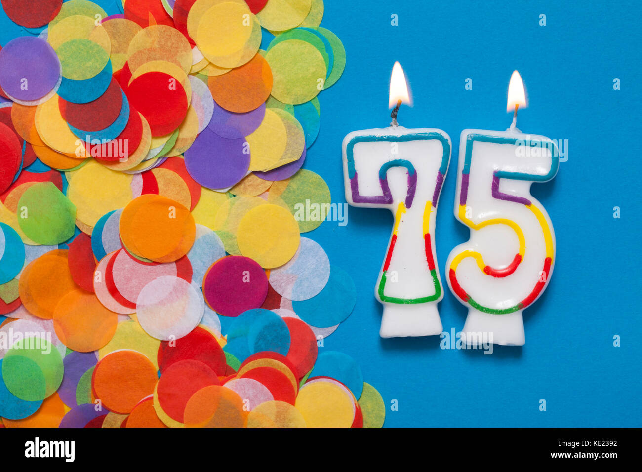 Number 75 celebration candle with party confetti Stock Photo - Alamy