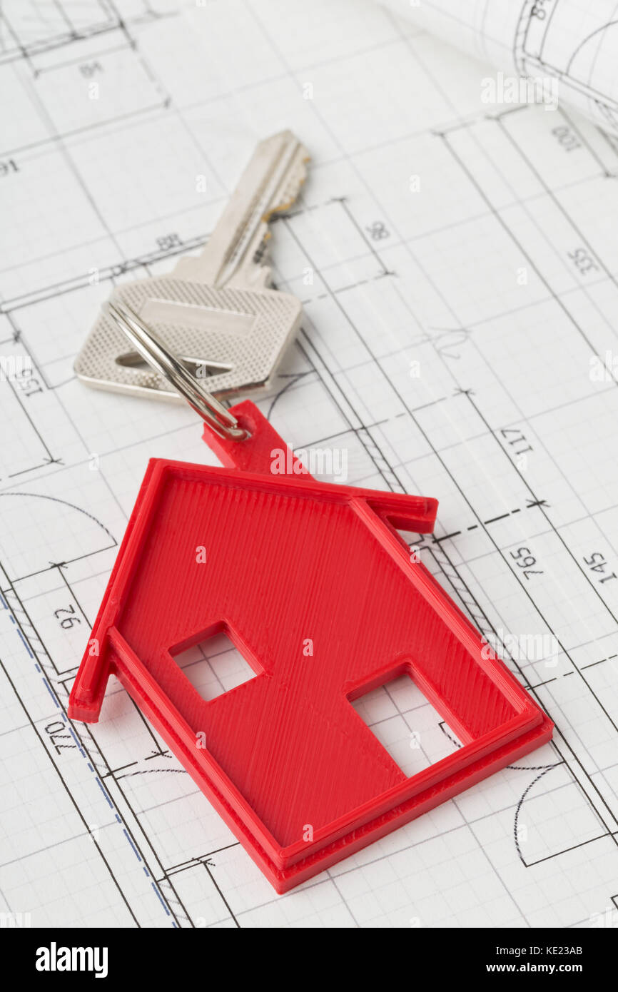 House door key with red house key chain pendant on building plans ...