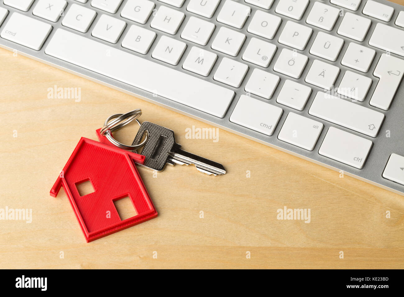 House door key with red house key chain pendant and computer keyboard ...