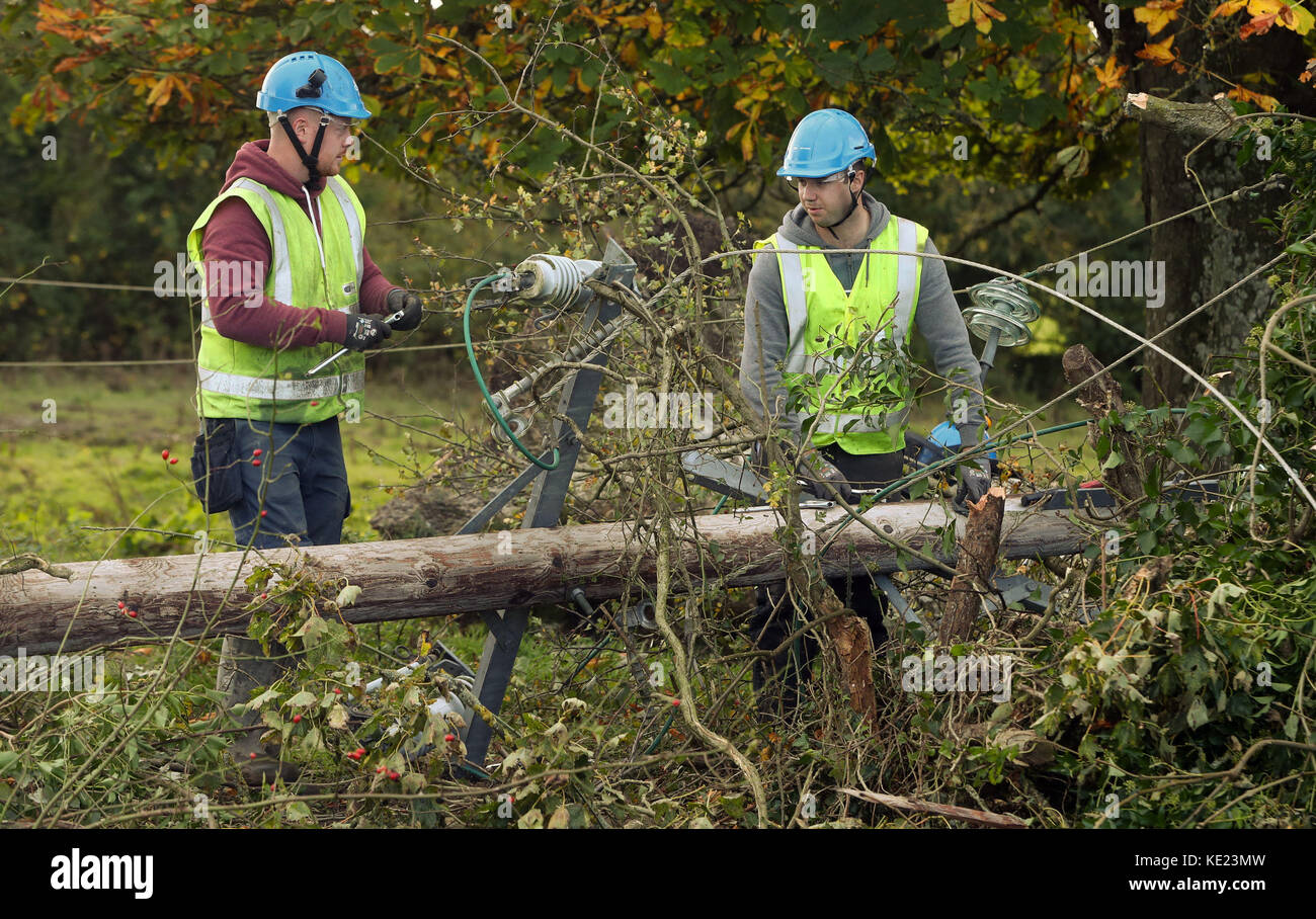 Workers in Kilcock, Ireland, clear fallen power lines after Hurricane ...