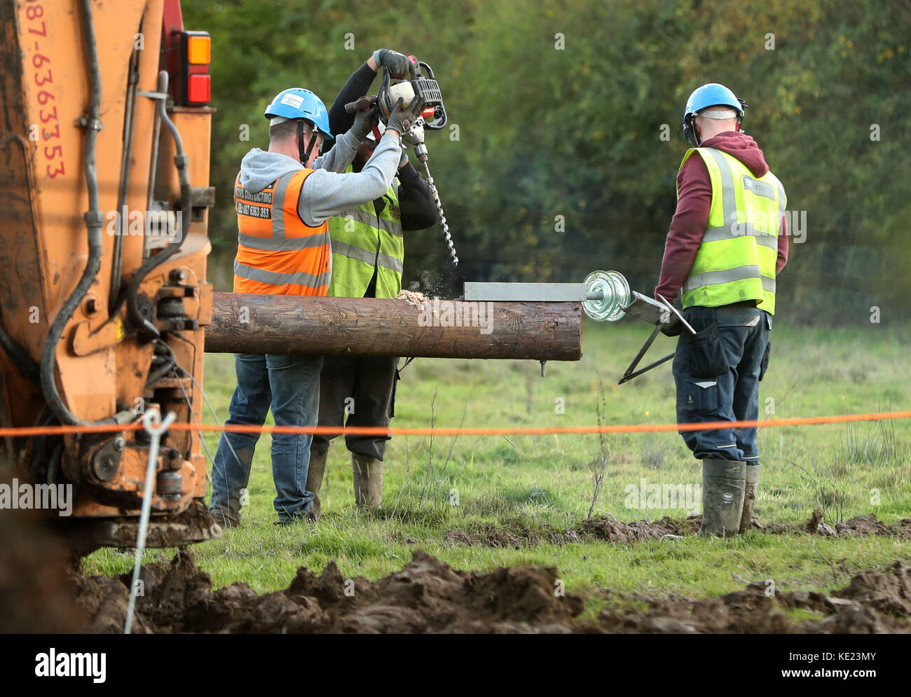 Workers in Kilcock, Ireland, clear fallen power lines after Hurricane ...
