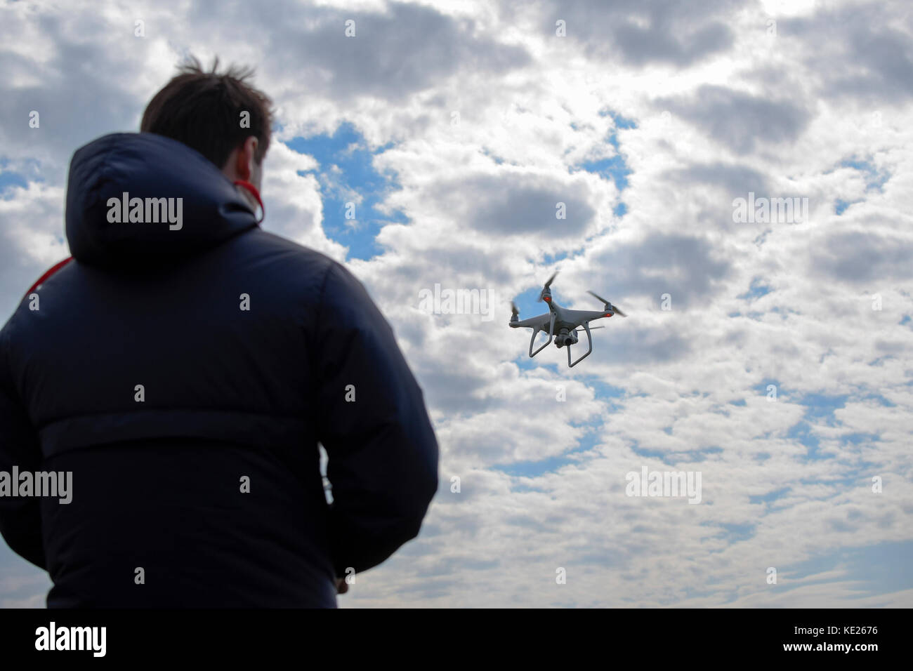 A man with a remote control in his hands. Controlling the flight of the ...