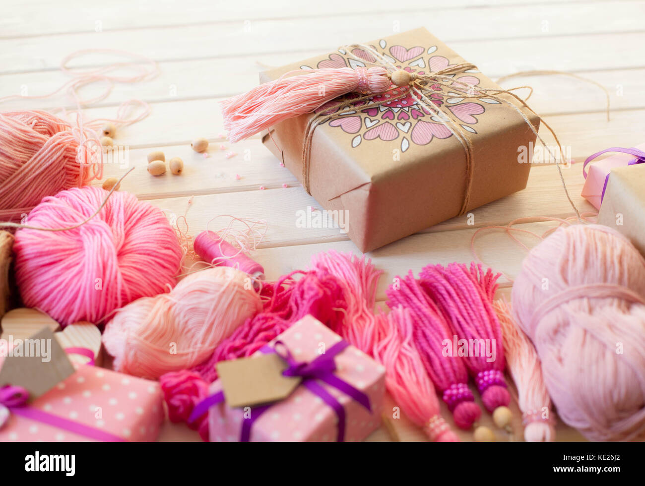 Pink tassels. Background of white wood. Women's handicrafts. The ...