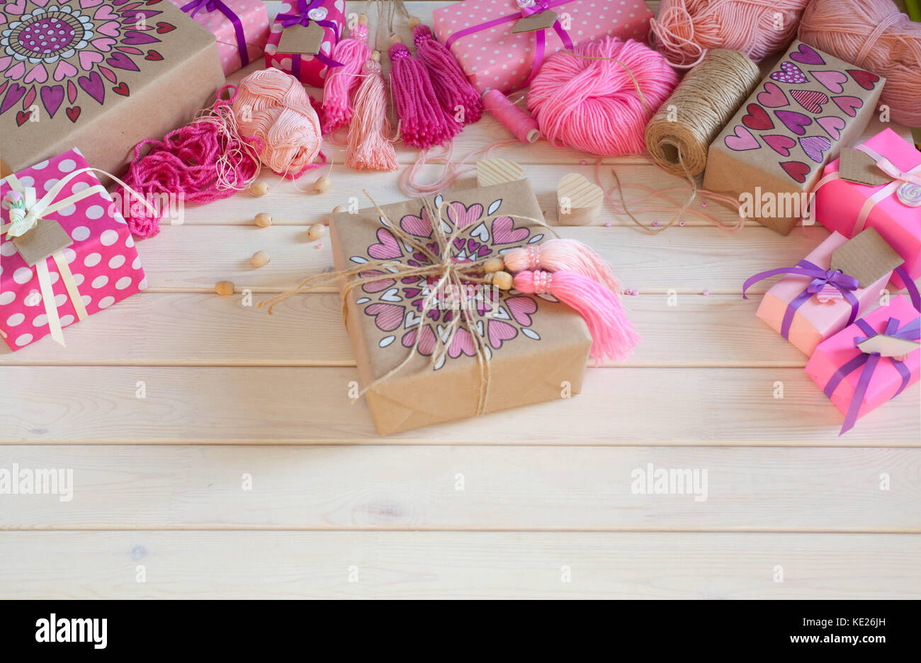 Pink tassels. Background of white wood. Women's handicrafts. The ...
