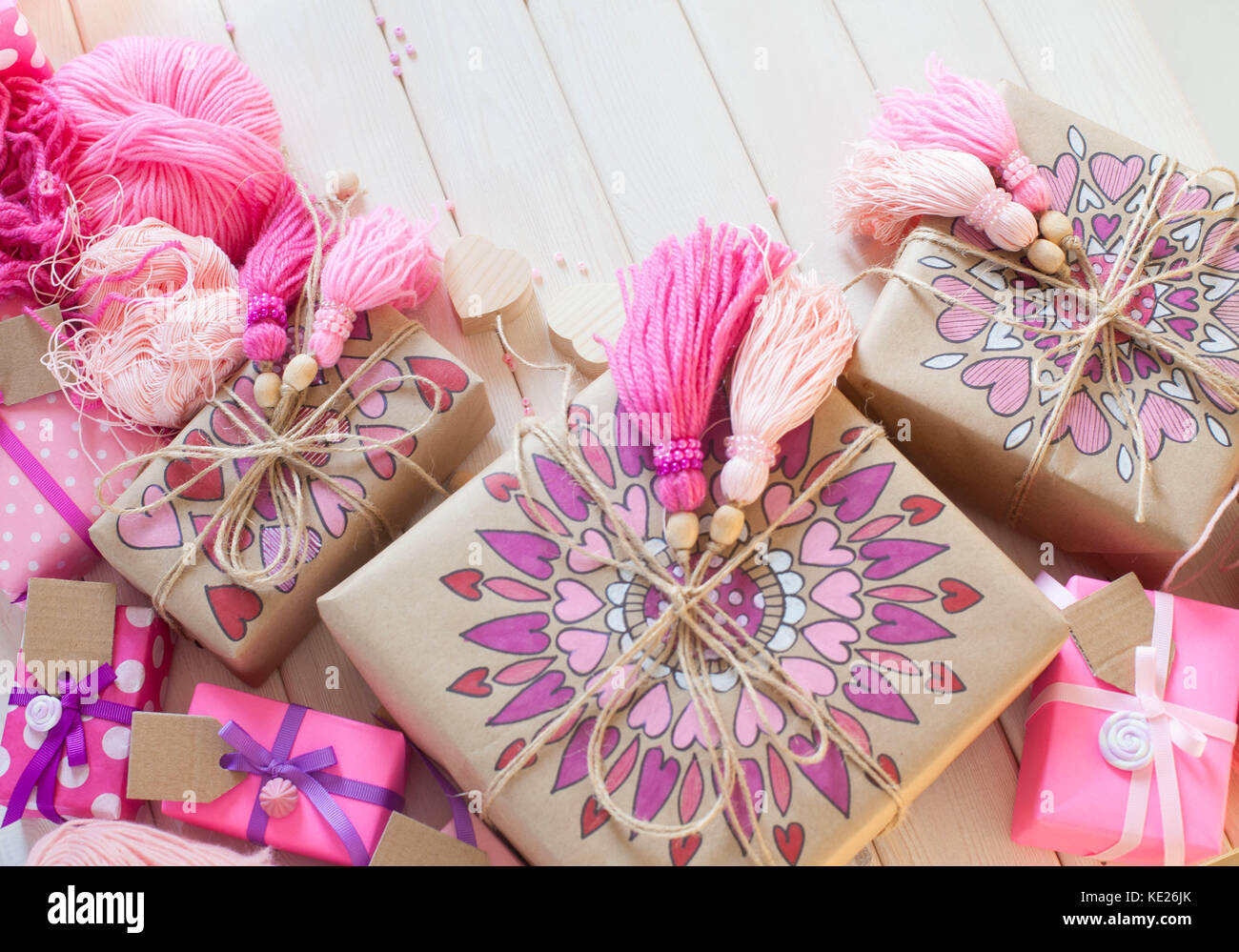 Pink tassels. Background of white wood. Women's handicrafts. The ...