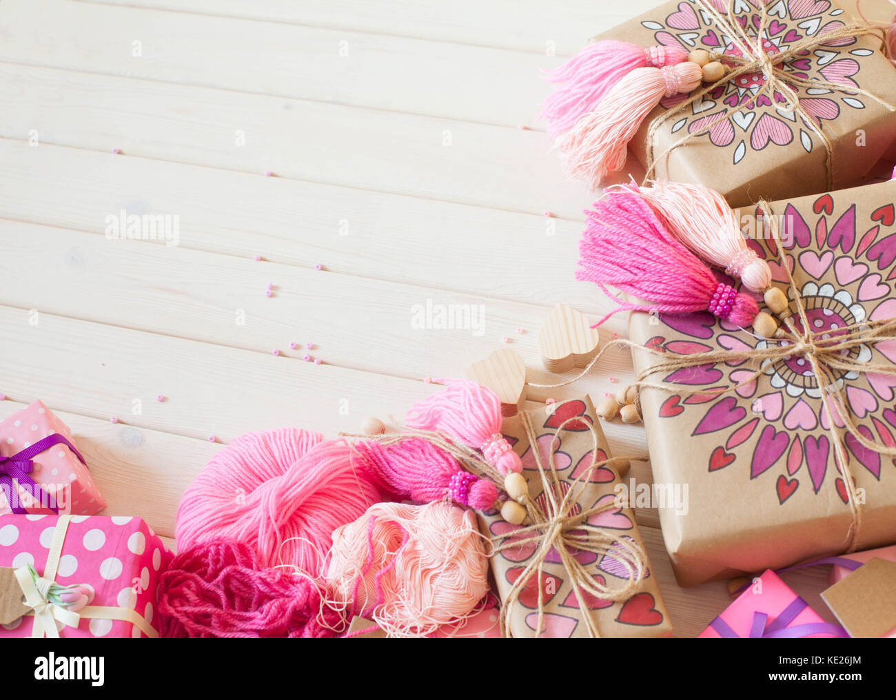 Pink tassels. Background of white wood. Women's handicrafts. The ...