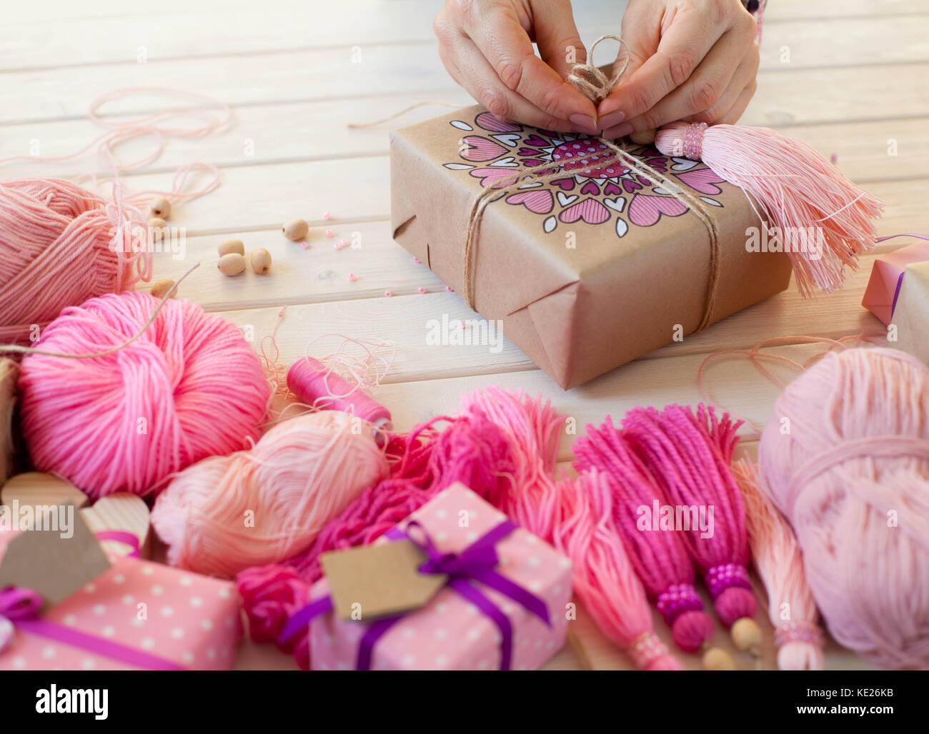 Pink tassels. Background of white wood. Women's handicrafts. The ...