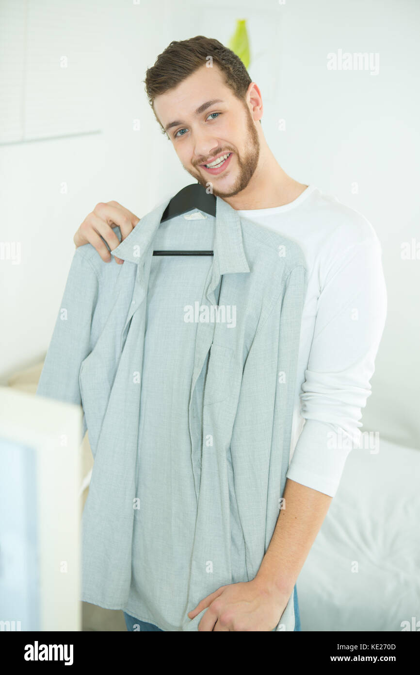 young man trying a shirt on Stock Photo - Alamy