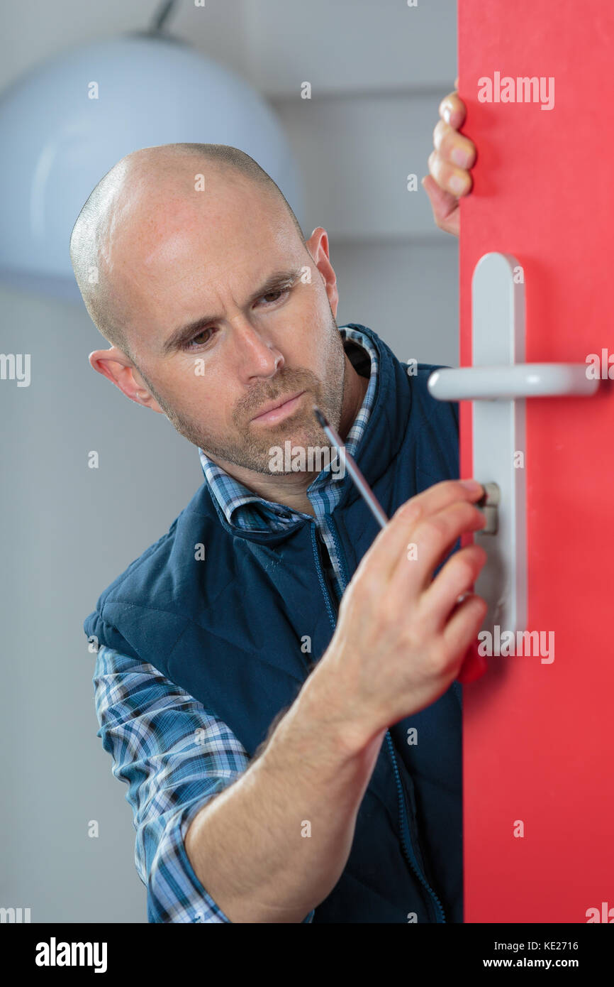 carpenter with doorlock during lock process installation Stock Photo ...