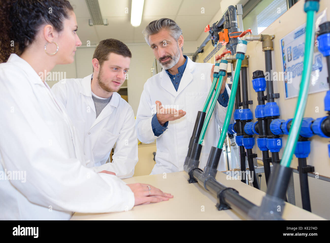 plumbers teaching students how to place plastic pipes Stock Photo - Alamy