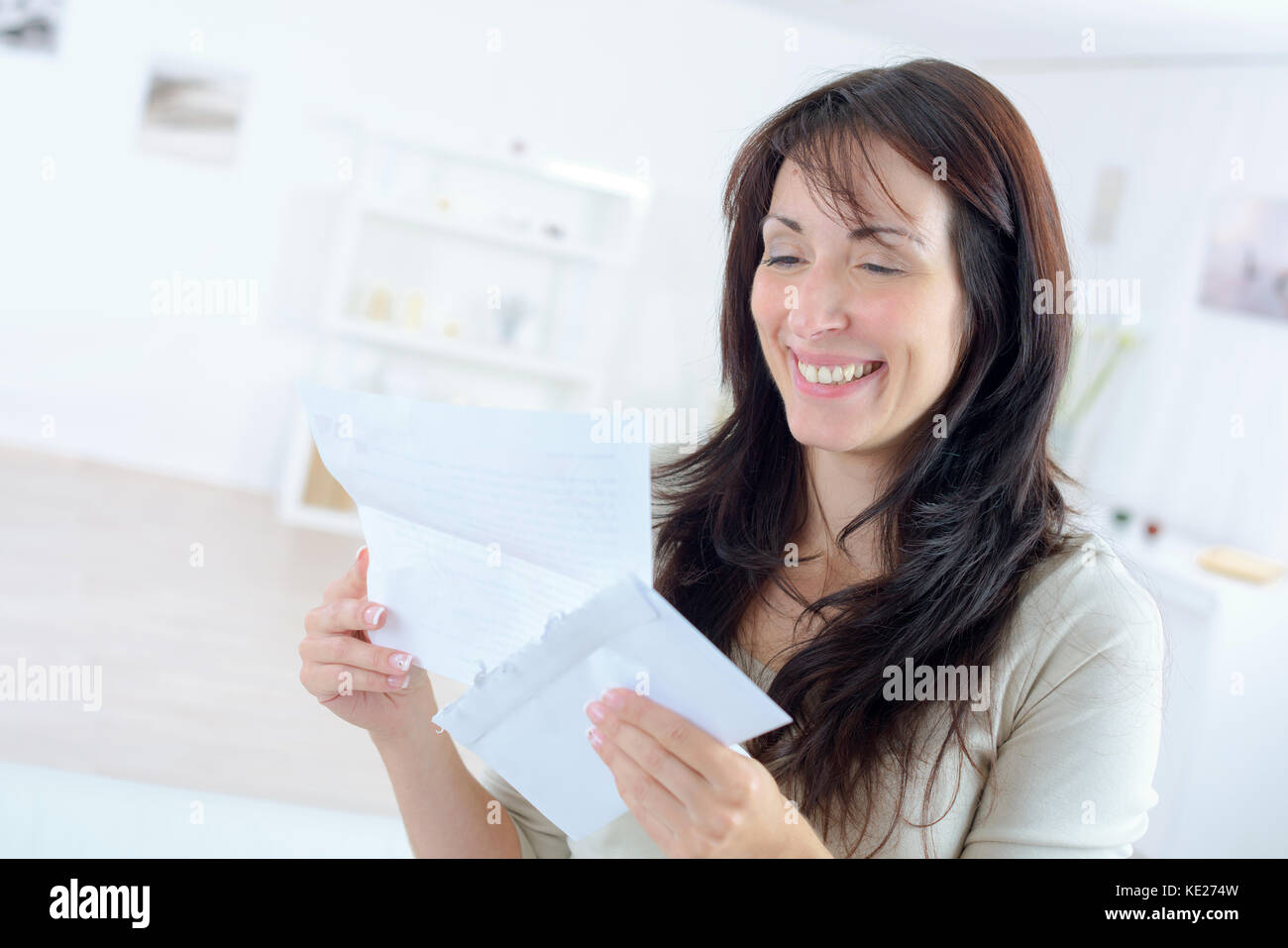 woman smiling while reading a letter Stock Photo - Alamy