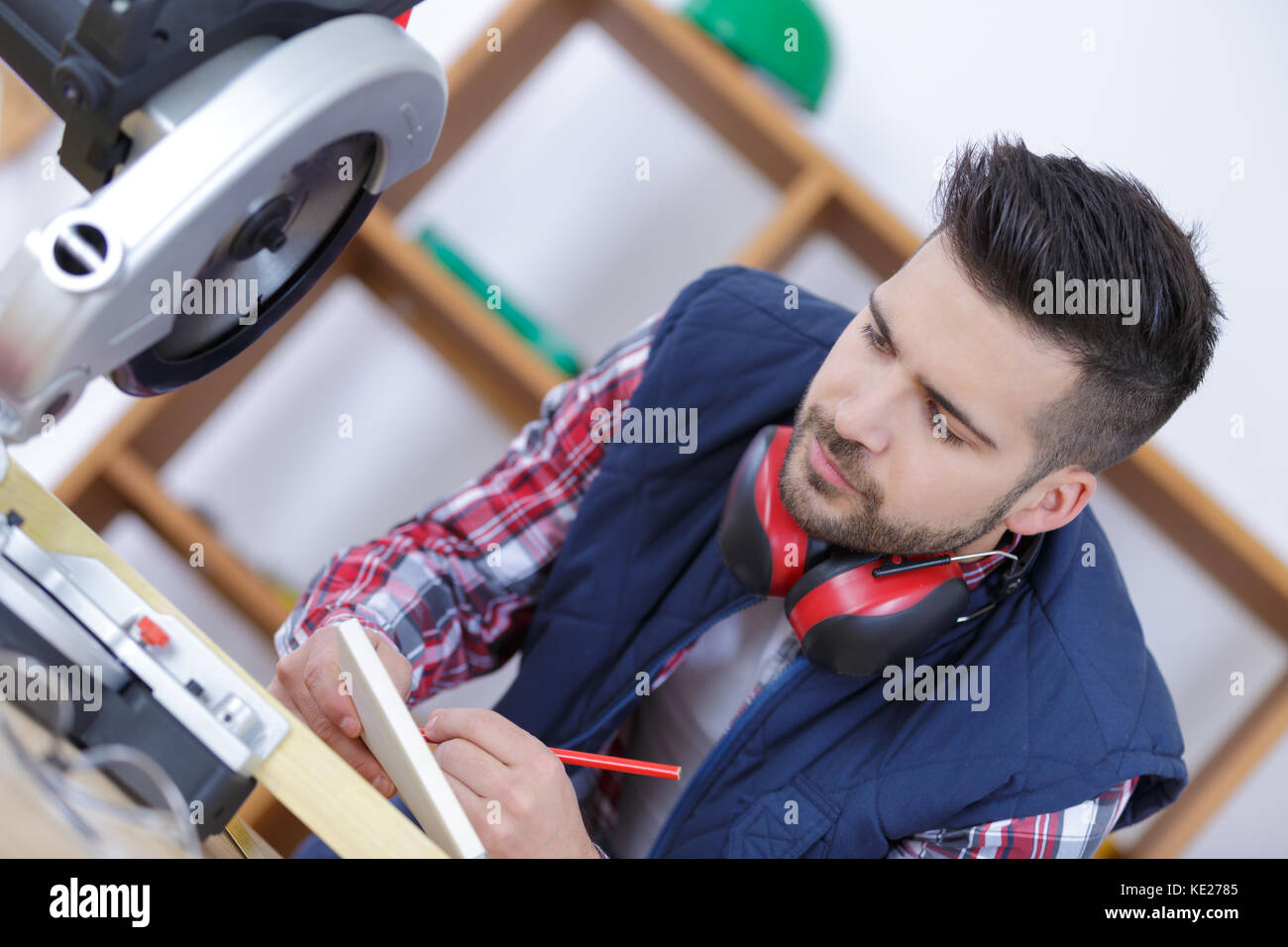 professional workman cutting wooden planks using circular saw in ...