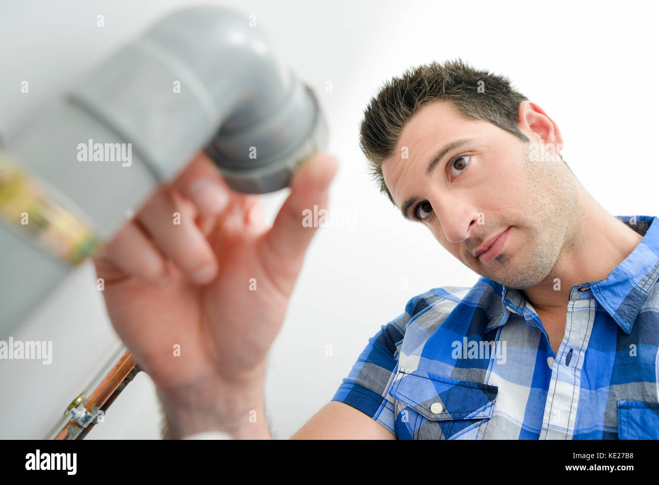 Plumber checking a plastic pipe Stock Photo - Alamy